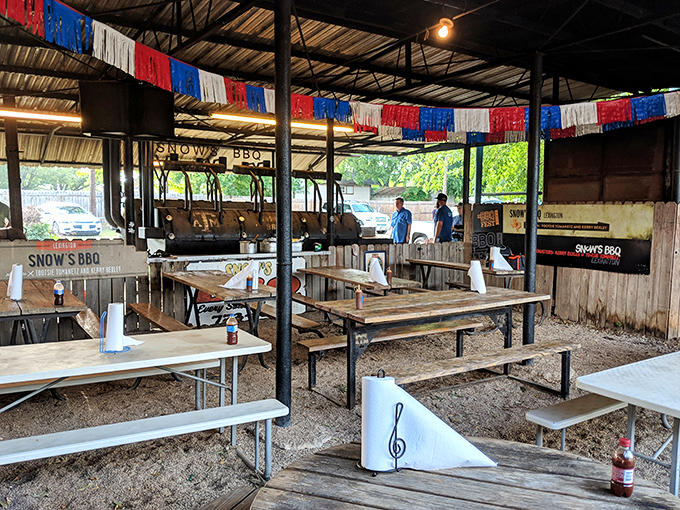 The outdoor dining area where smoke, conversation, and Texas pride mingle freely under the corrugated metal roof.