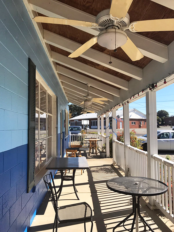 The sun-dappled porch offers al fresco dining with a side of small-town charm—ceiling fans lazily spinning overhead like time itself slowing down for your meal.