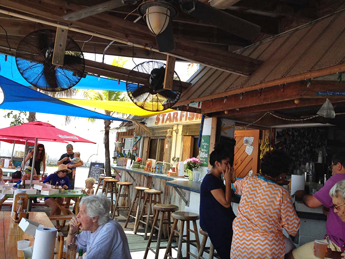Waterfront dining at its most authentic &ndash; colorful umbrellas shade wooden picnic tables where boats bob gently in the background.