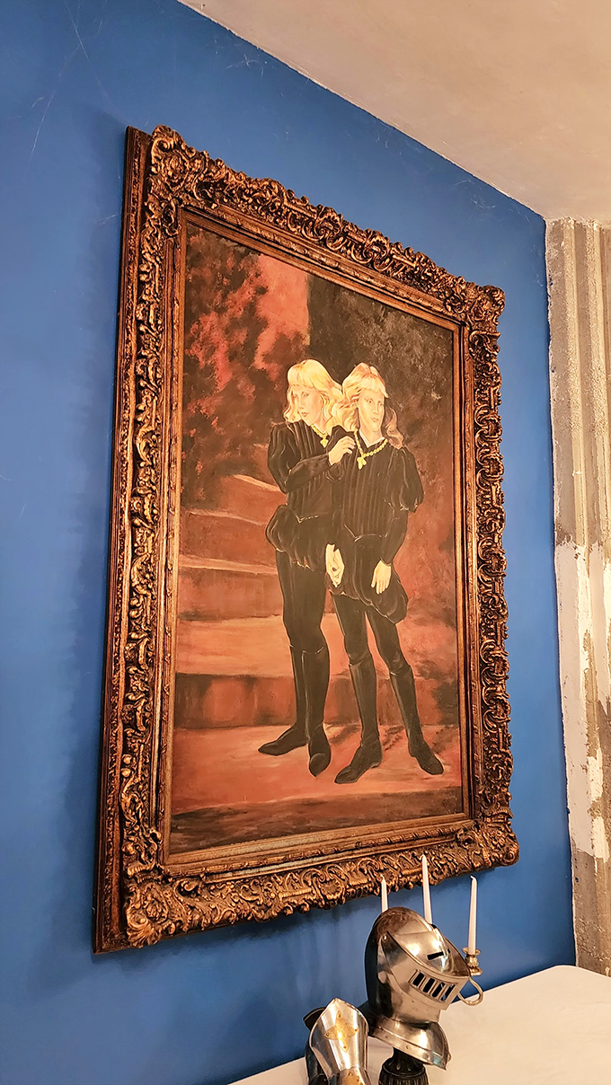 Period-appropriate artwork adorns blue walls, transporting visitors to a time of knights, noble quests, and questionable dental practices.