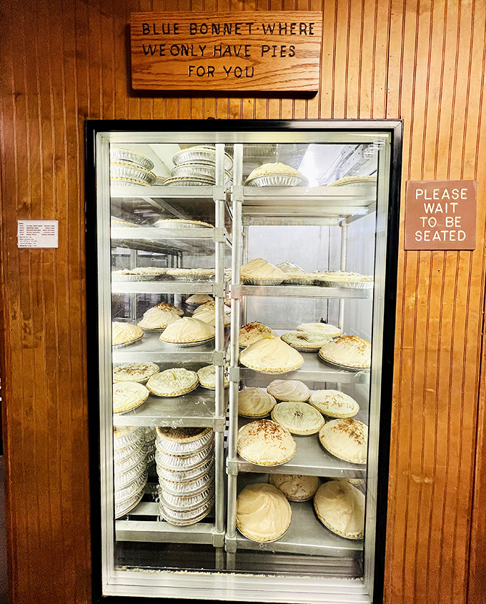 The pie case: a glass-fronted temple where meringue reaches architectural heights that would make Frank Lloyd Wright nod in professional respect.