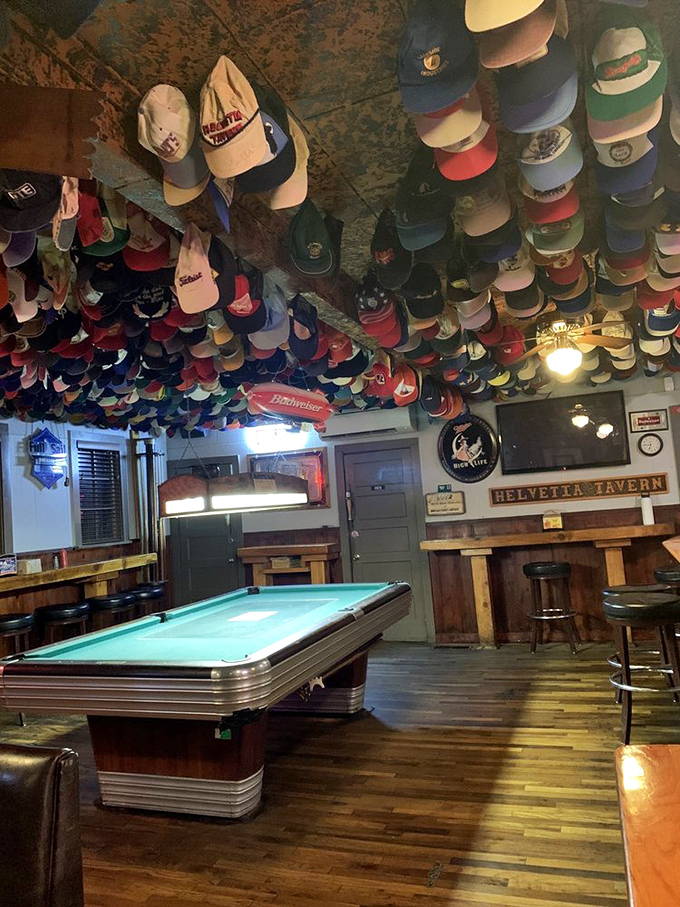 Where billiards and burgers meet under a canopy of caps—the tavern's game room invites you to stay awhile.