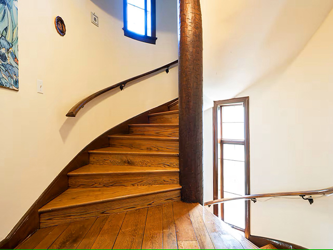 The curved wooden staircase winds upward like something from Hogwarts, each step worn smooth by countless footfalls through the years.