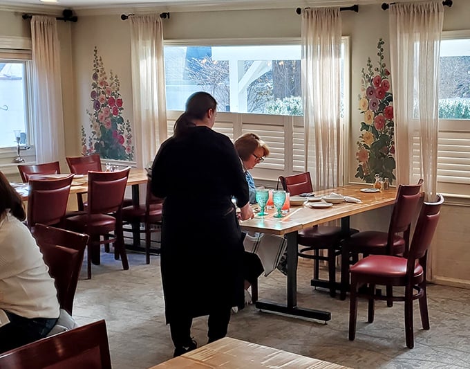 The dining area's floral murals and natural light create an atmosphere that's both elegant and homey&mdash;like Sunday dinner at your fancy aunt's house.