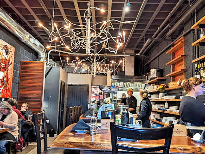 Modern industrial elements blend with warm wood tones in this thoughtfully designed space. The artistic lighting fixture adds a touch of whimsy to the serious business of serving outstanding seafood.