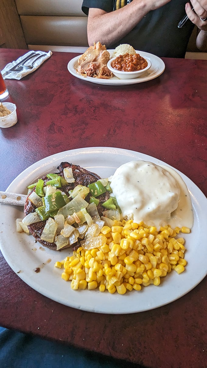 A hamburger steak that's lived a good life, now resting peacefully beside mashed potatoes and corn. The circle of deliciousness is complete.