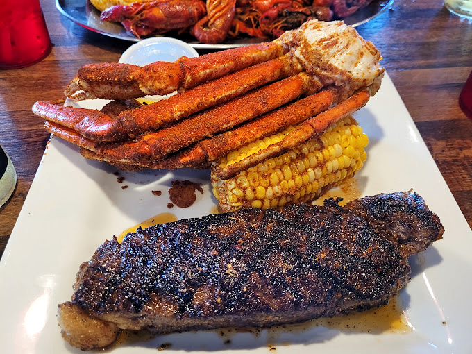 Surf meets turf in spectacular fashion. Those crab legs look like they're trying to steal the spotlight from that perfectly blackened steak.