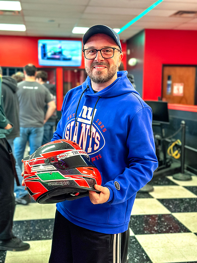 A racer proudly displays his helmet, having achieved that perfect "I'm taking this seriously enough to look cool but not weird" racing balance.