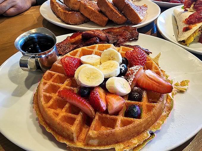 A waffle that's achieved the perfect tan, adorned with nature's candy and ready for its maple syrup shower.