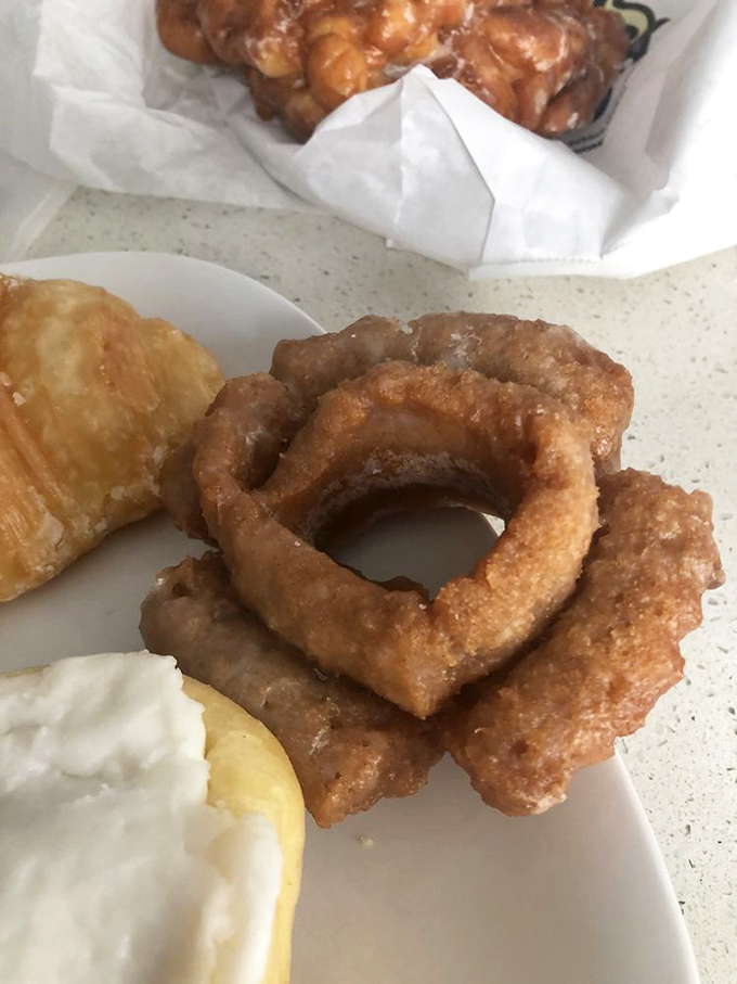 The cross-section tells the story: perfectly fried dough meeting smooth custard filling, topped with chocolate. Engineering at its most delicious.