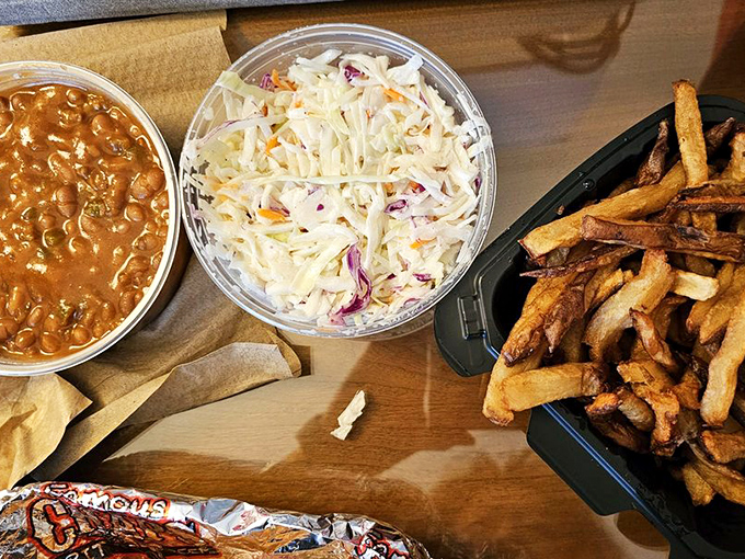 The supporting cast deserves applause too: creamy coleslaw, hearty baked beans, and hand-cut fries form the perfect backup band for your meat concert.