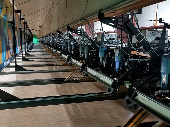 Behind the scenes, the mechanical wizardry of modern pinsetters works tirelessly, a testament to bowling's evolution from manual pin boys to automation.