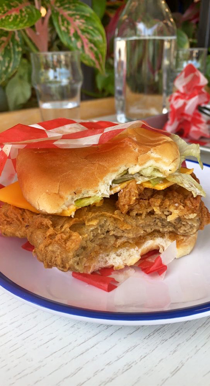 This isn't just a sandwich&mdash;it's architecture you can eat. The cross-section reveals the perfect ratio of crispy chicken to fresh toppings.