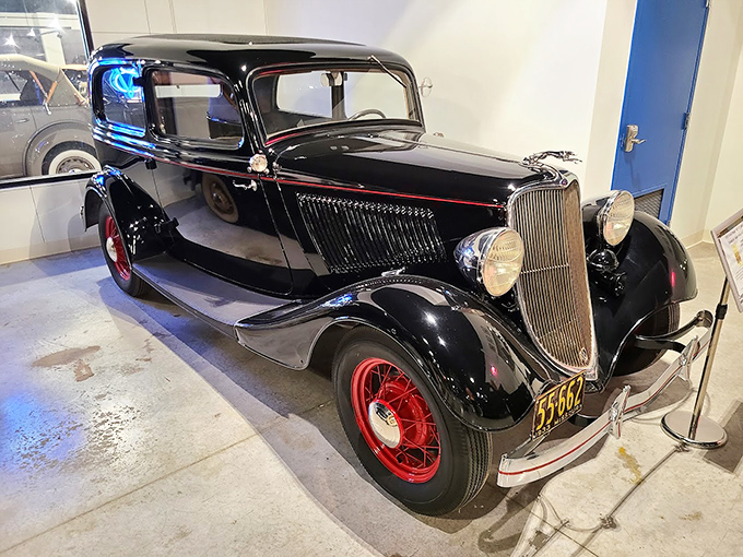 The 1933 Ford Tudor exudes Prohibition-era coolness with its sleek black finish and red wheels. You can almost hear the jazz playing as it cruises by.