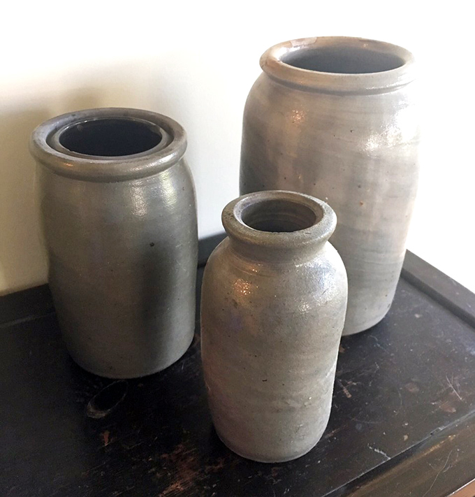 Stoneware crocks that once preserved summer's bounty now preserve history itself. Perfect vessels for kitchen utensils or dramatic flower arrangements.