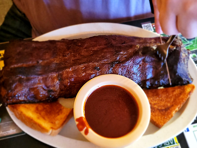 Ribs so substantial they look like they could have their own ZIP code. That sauce cup is just trying to keep up with greatness.