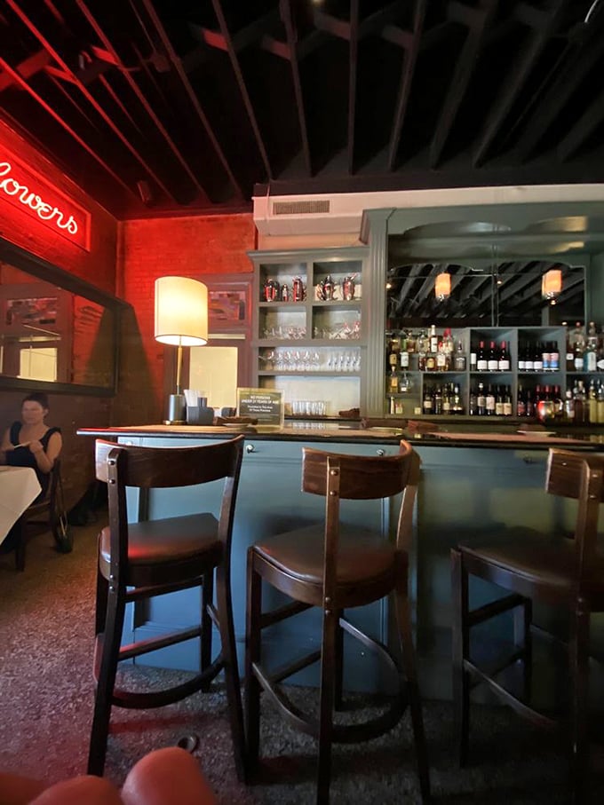 The bar area where cocktail magic happens. That red neon glow isn't just lighting&mdash;it's a mood you can sip slowly.