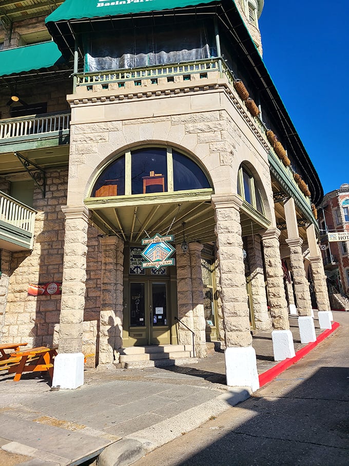 The Basin Park Hotel's distinctive corner entrance anchors downtown like an old friend, its stone columns and green awnings unchanged by passing decades.