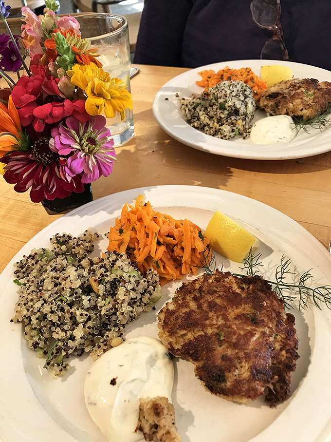Two plates, one mission: to prove that crab cakes, quinoa, and fresh flowers are the holy trinity of civilized dining.