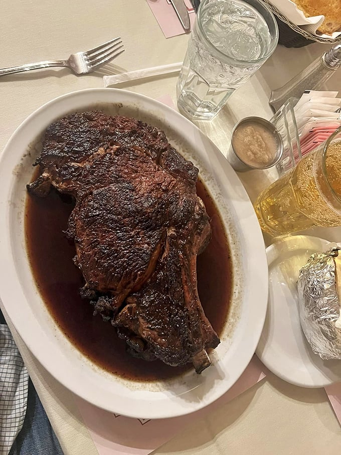 This bone-in masterpiece swimming in au jus isn't just a steak; it's a primal reminder of why our ancestors fought their way to the top of the food chain.