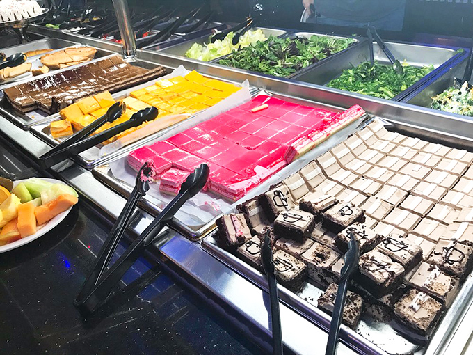 The dessert section offers a colorful spectrum of sweet endings, from mysterious pink squares to chocolate brownies that dare you to save room.