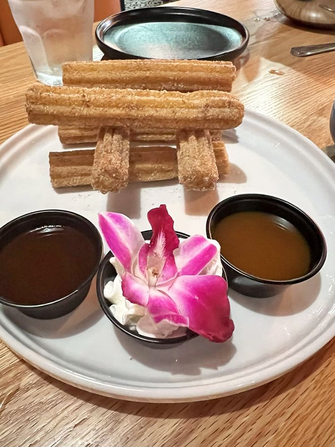 Churros stacked like delicious Lincoln Logs of happiness. The chocolate dipping sauce makes a compelling case for dessert being mandatory, not optional.