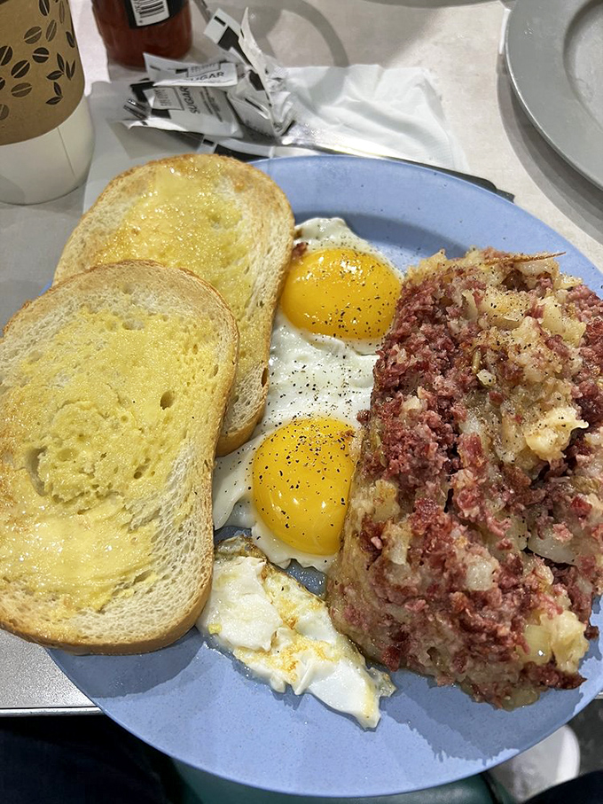 Corned beef hash with sunny-side-up eggs&mdash;a breakfast that respects tradition while satisfying modern appetites. Those butter-soaked toast slices are standing by for yolk duty.
