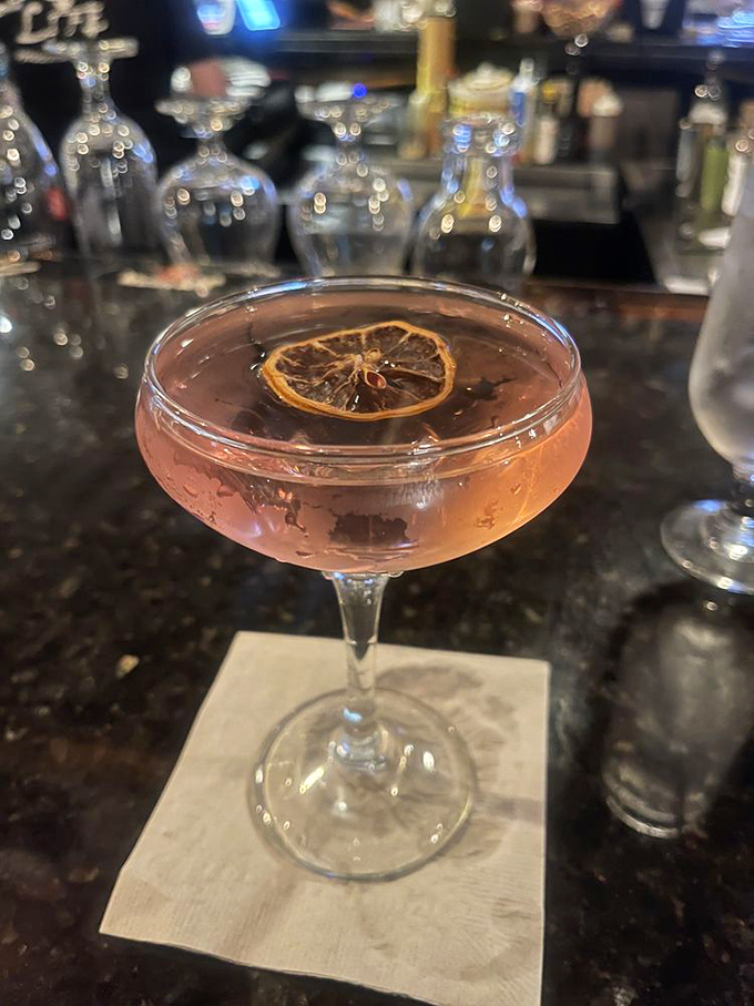 A cocktail garnished with dried citrus &ndash; proof that even the beverages here are dressed for success. Like a tiny edible work of art.