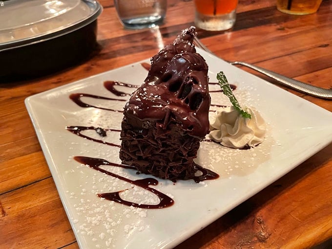 Chocolate cake architecture that deserves its own building permit, drizzled with sauce that would make Willy Wonka jealous.