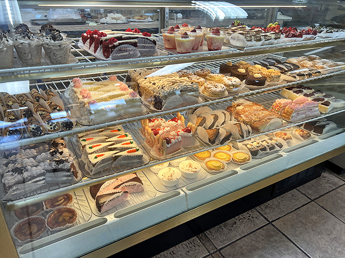 The display case is like a museum of edible art where every shelf offers a new reason to abandon your diet resolutions.