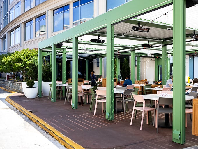The outdoor dining structure blends seamlessly with the building's architecture. These green-framed havens offer al fresco dining with a touch of sophistication.