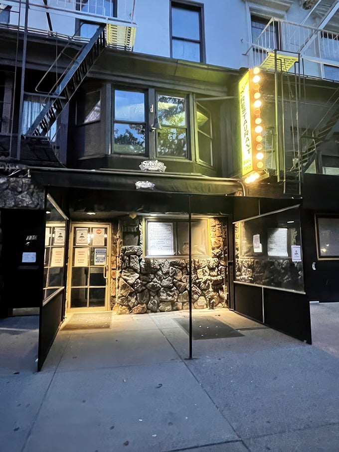 As evening falls, the restaurant's glowing sign serves as a beacon for hungry souls seeking culinary salvation in Harlem.