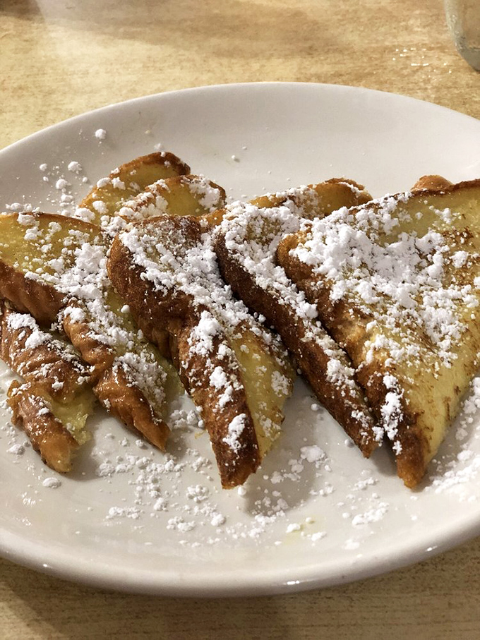 French toast transformed into dessert for breakfast&mdash;powdered sugar snowdrifts on golden bread islands. Your pancreas is already writing its resignation letter.