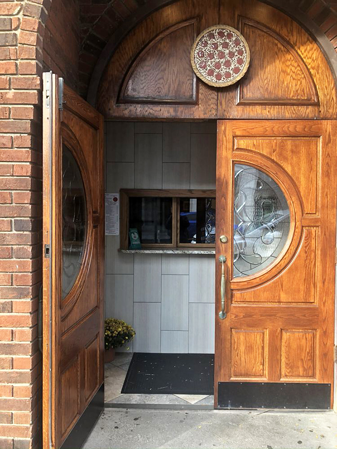A wooden door with stained glass and a pizza medallion. Not the pearly gates, but for food lovers, it's pretty close.