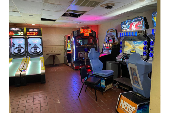 The arcade corner offers electronic respite for those waiting their turn or recovering from the emotional devastation of a missed spare.