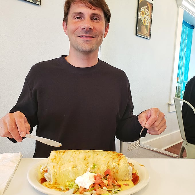 The universal expression of "I've found my happy place" as a diner prepares to tackle a burrito that requires both hands and commitment.