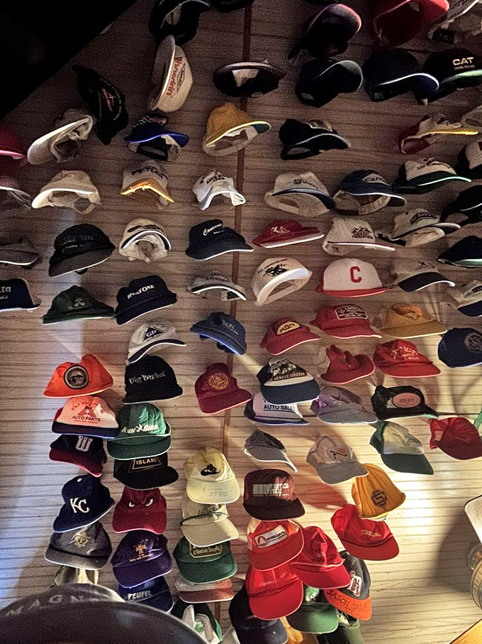 Look up! The hat collection continues, a textile tapestry representing decades of visitors who left a piece of themselves behind.