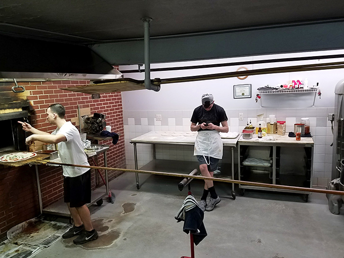 Behind the scenes in pizza headquarters, where dough becomes legend. That brick oven has more stories than most neighborhood bars. 