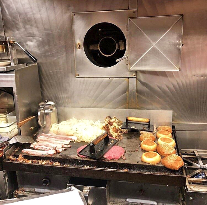 The beating heart of Mickey's: a well-seasoned griddle where bacon sizzles, buns toast, and hash browns achieve their perfect golden-brown destiny.