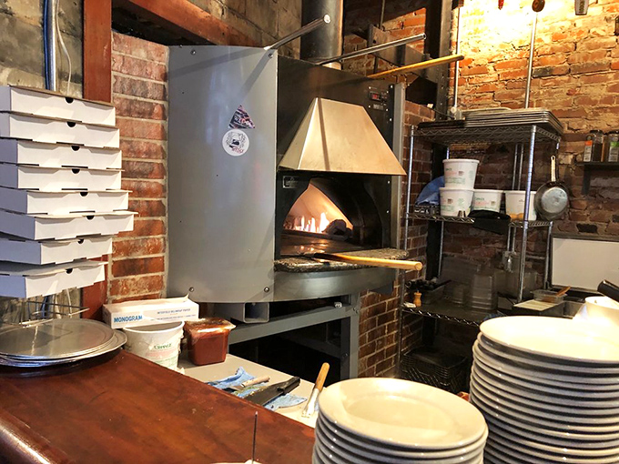 Where the magic happens! The wood-fired oven glows with promise, ready to transform simple dough into crispy, bubbly masterpieces in minutes.