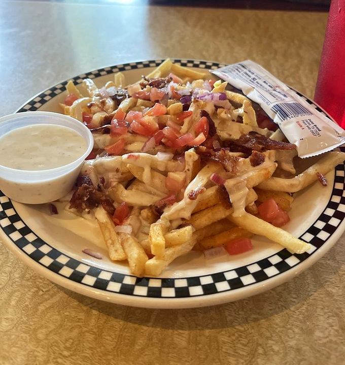 These loaded fries wear more toppings than a celebrity on a red carpet&mdash;bacon, cheese, and tomatoes creating a delicious traffic jam.