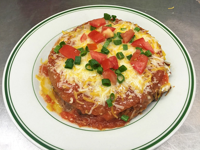 This Mexican pizza laughs at chain restaurant versions. Melted cheese, bright tomatoes, and green onions create a fiesta of flavors on a crispy tortilla base.
