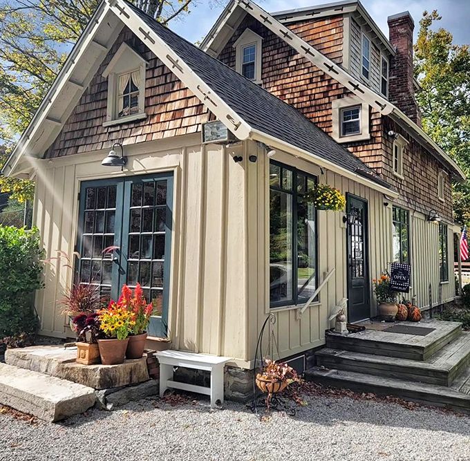 Charming cedar shingles and warm autumn blooms welcome you into this cozy cottage, where every rustic detail feels like home.