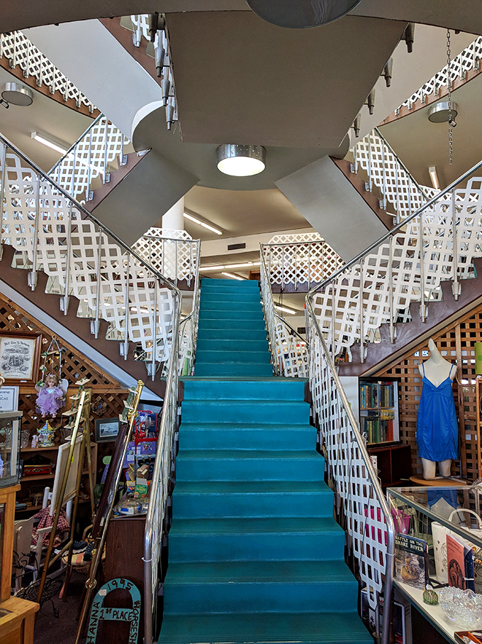 The turquoise staircase ascends like a portal to another dimension of vintage wonders, framed by charming lattice railings.