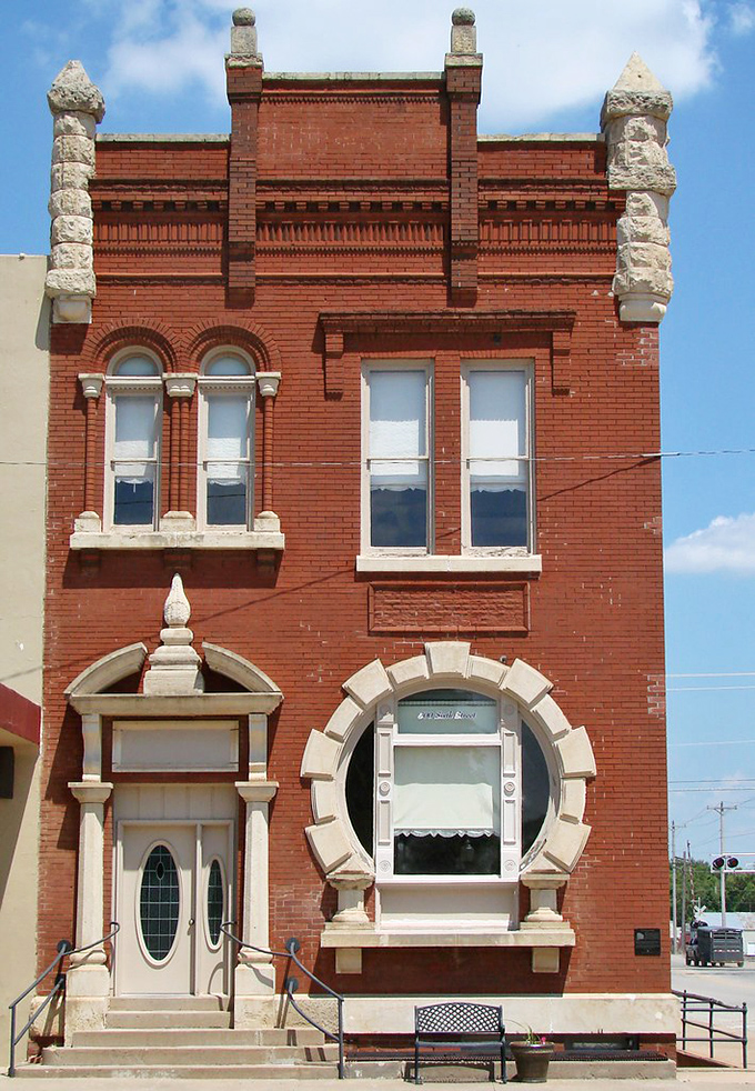 The Noble County Bank building's ornate stonework and circular window showcase an era when financial institutions were built to inspire confidence and awe.
