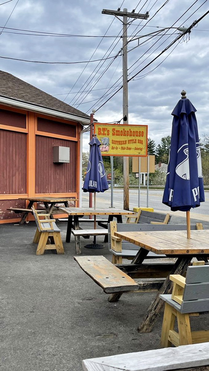 Outdoor picnic tables where summer dreams happen. Those blue umbrellas have witnessed countless barbecue epiphanies.
