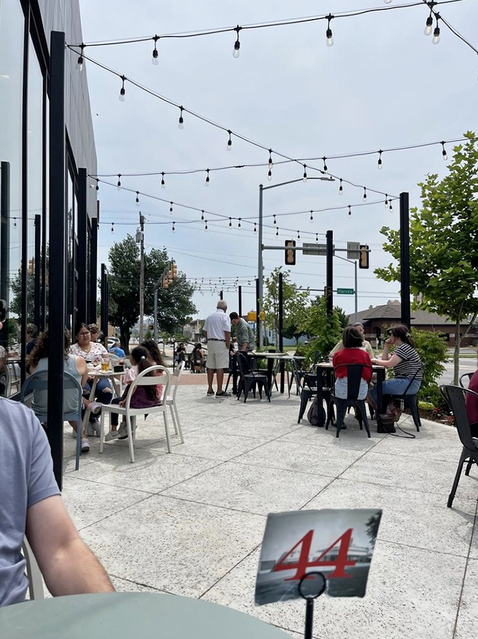 String lights hover above outdoor tables like breakfast fairies blessing conversations and coffee cups with equal enthusiasm under Oklahoma skies.