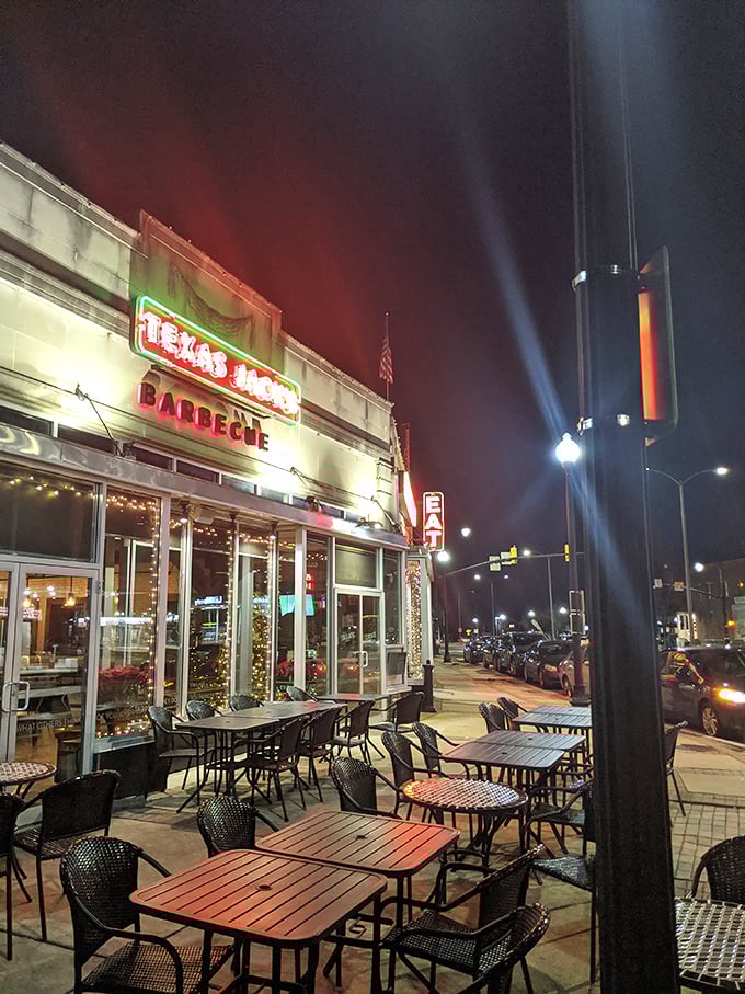 Nighttime at Texas Jack's transforms the patio into an urban oasis where the neon glow promises delicious decisions await inside.