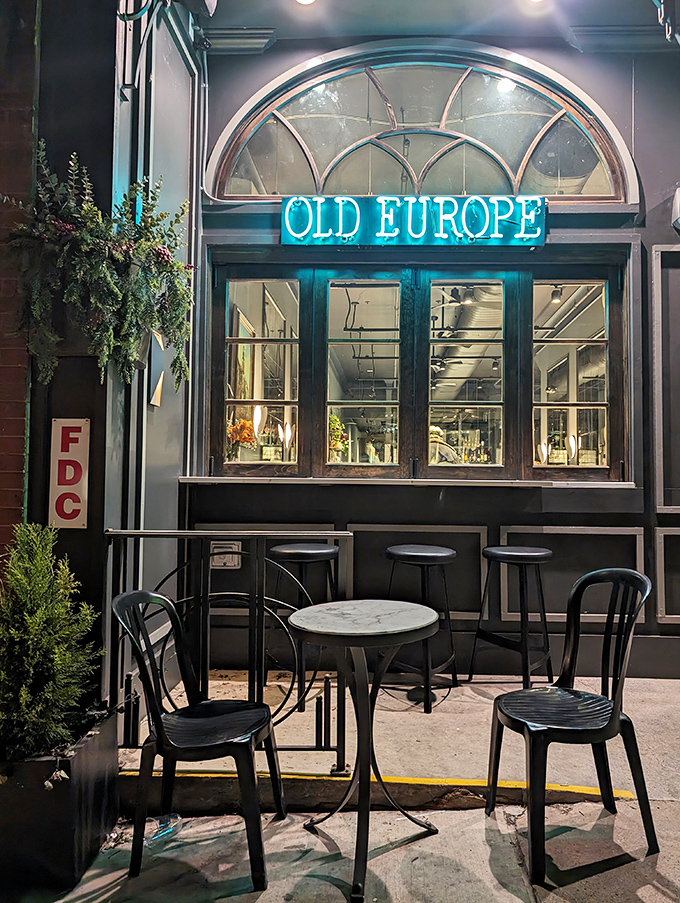 Nighttime transforms the caf&eacute;'s exterior into a cozy sanctuary. That blue neon sign serves as a beacon for dessert emergencies after dark.