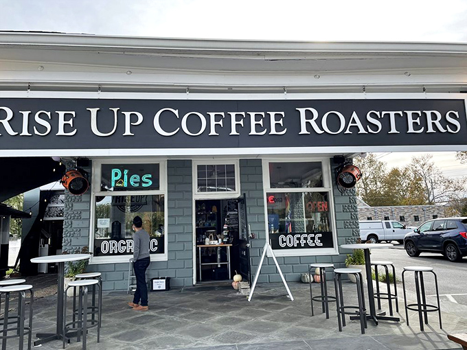 The blue-gray exterior with its glowing "Pies" sign offers a roadside promise of coffee excellence and pastry perfection.
